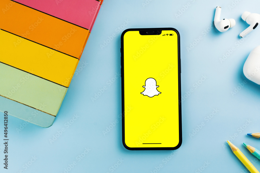 Snapchat app on the smartphone screen. Blue background with school ...