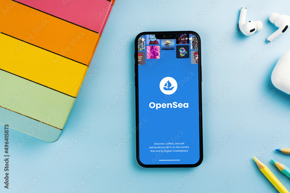 OpenSea NFT Marketplace app on the smartphone screen. Blue background ...