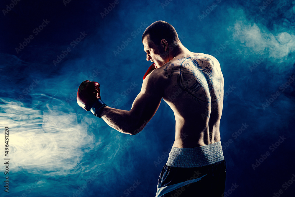 Side view of sportsman muscular boxer who fighting on black smoke ...