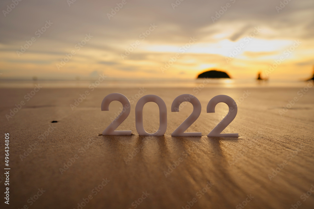 2022 message year on beach during sunset. Stock Photo | Adobe Stock