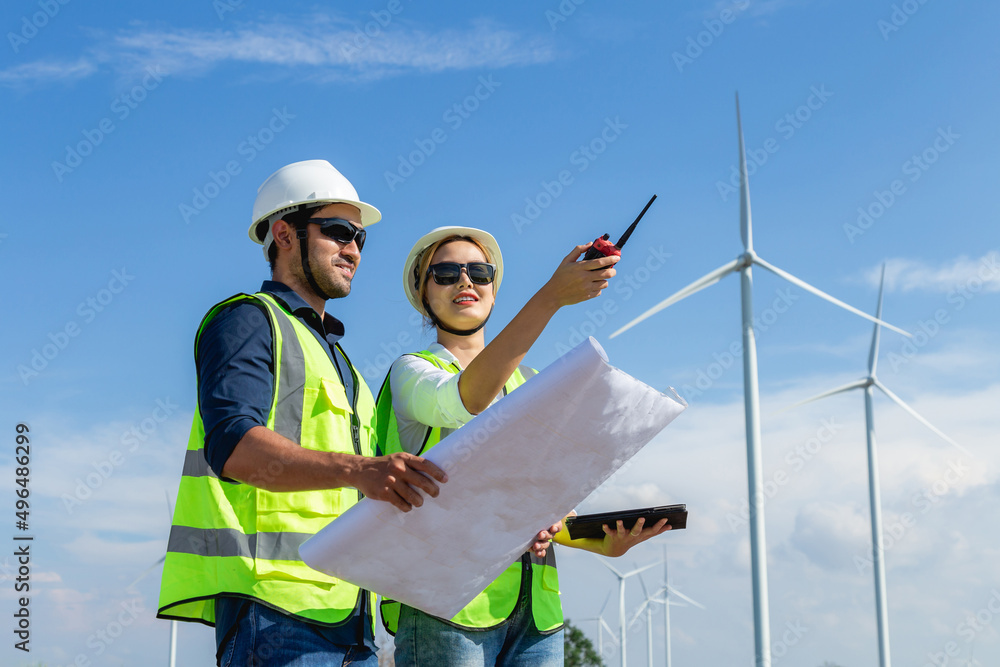 Asian man and woman engineers working on site in wind turbine on the ...