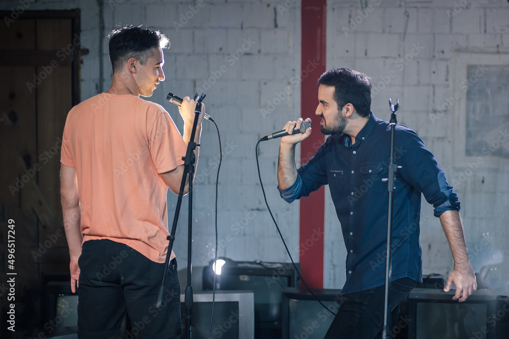 Smiling and witty stand up actor comedian on stage, talking and singing ...