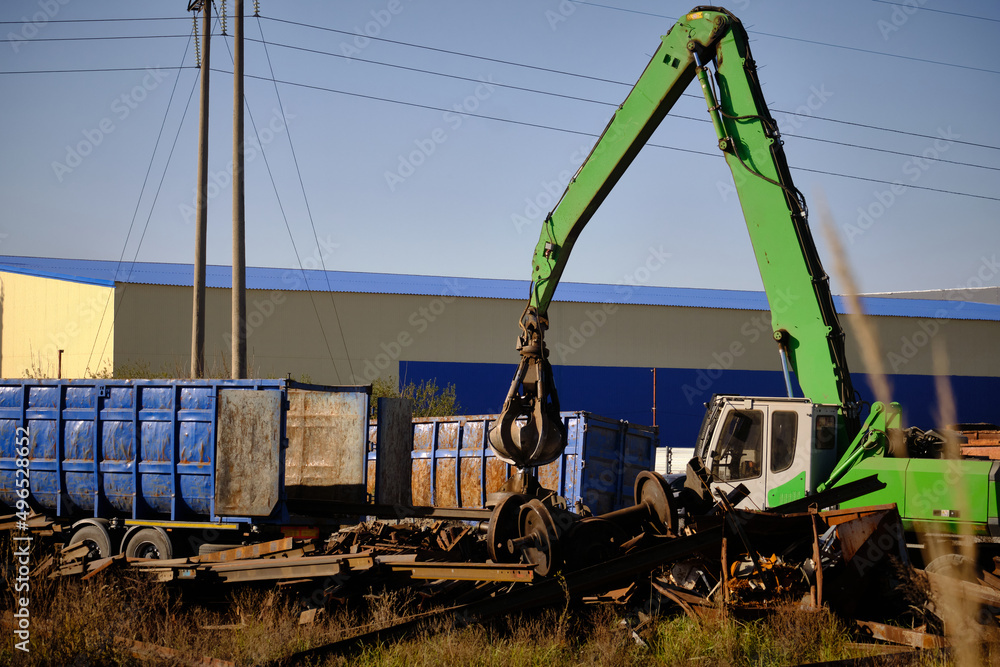 Grapper loader loads truck with scrap metal. Hand of grabber excavator ...