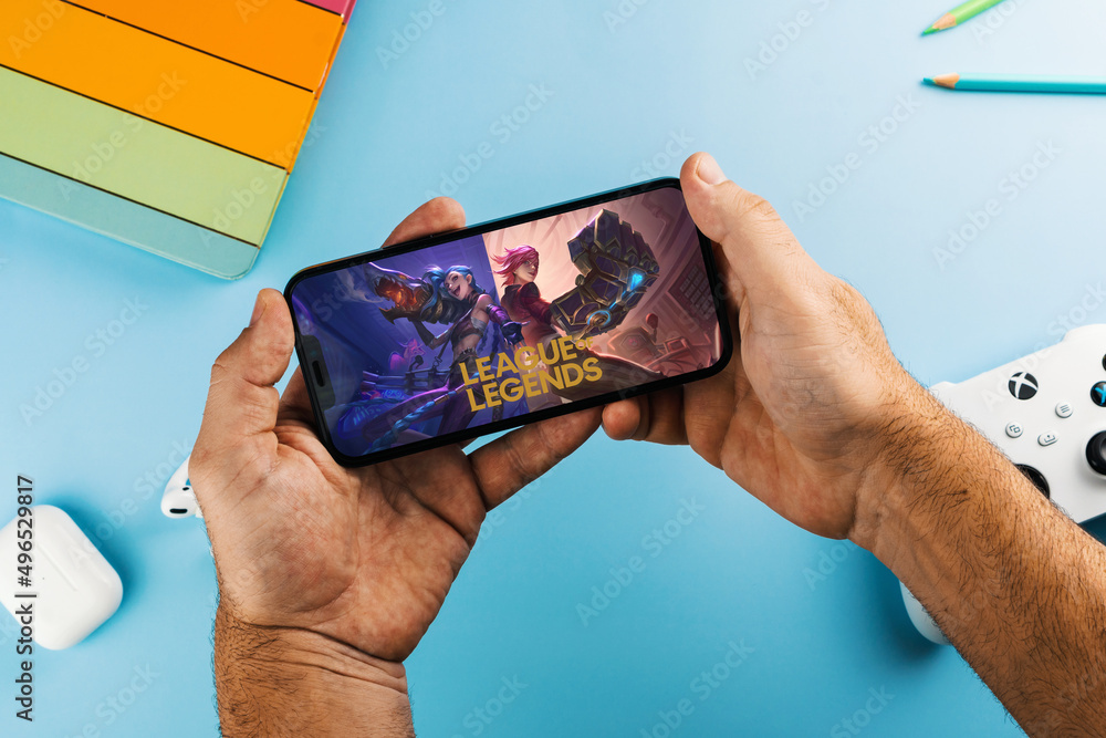 Man holding a smartphone with League of Legends (LOL) mobile game app ...