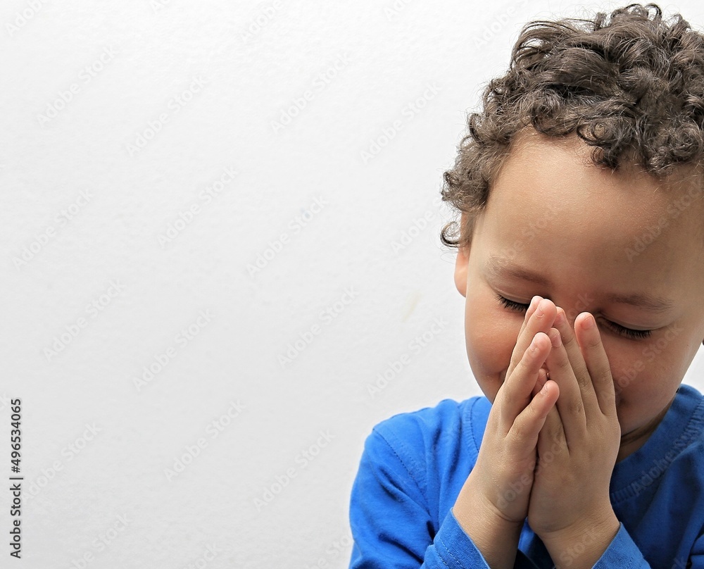 little boy praying to God with eyes closed with grey background stock ...