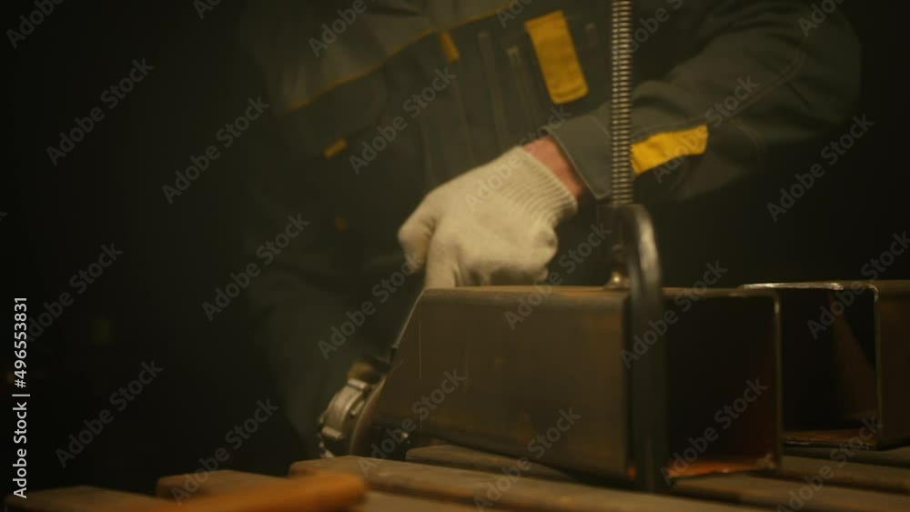 Worker grinding iron. Heavy industry factory interior with worker using ...