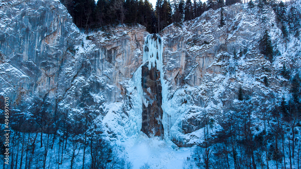 Fotka „Aerial drone view of frozen waterfall with some water running ...