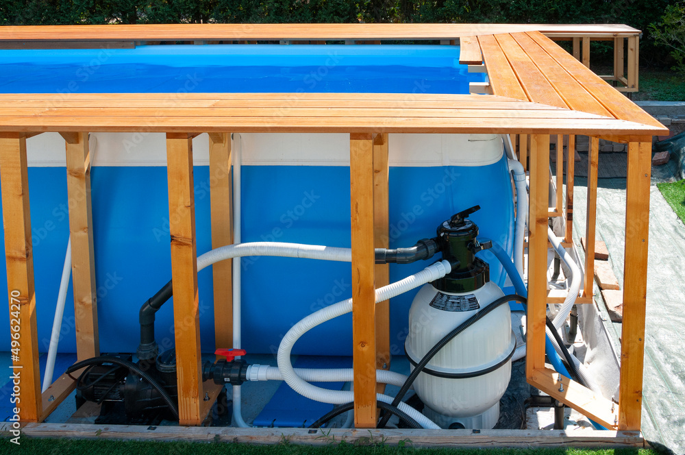 Swimming pool in the garden with wooden pool deck in construction and ...