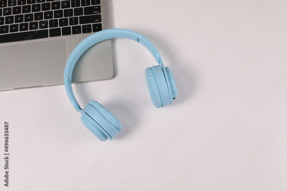 light blue headphones with laptop on white background. with white phone ...
