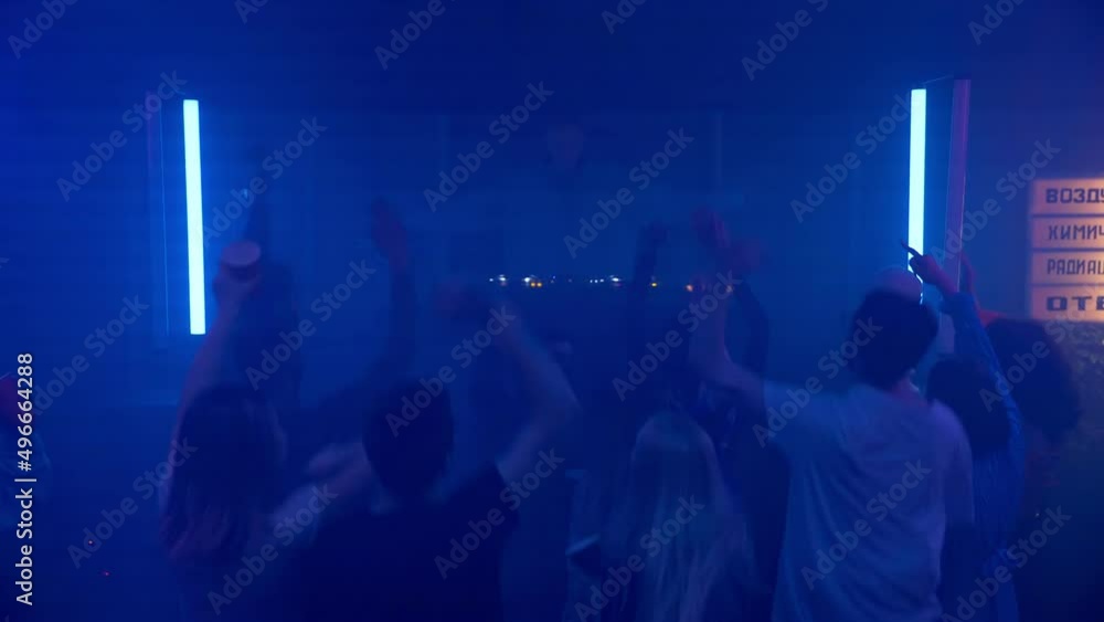 A crowd of people dancing on the dance floor of a nightclub under the ...