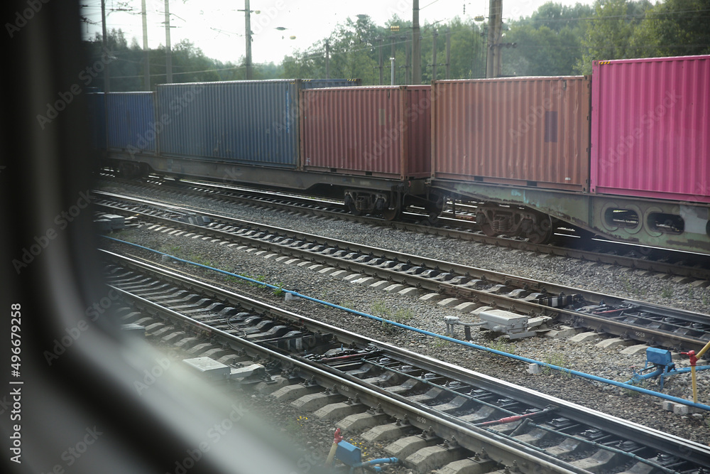 view from the train window to the railway station, freight train and ...