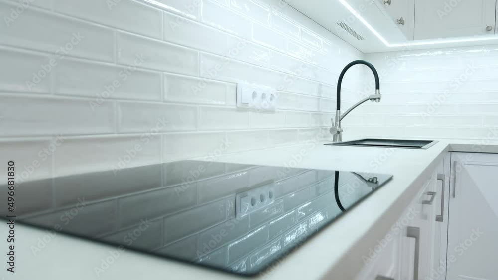 Modern kitchen with white tiles. glass hob Stock Video | Adobe Stock