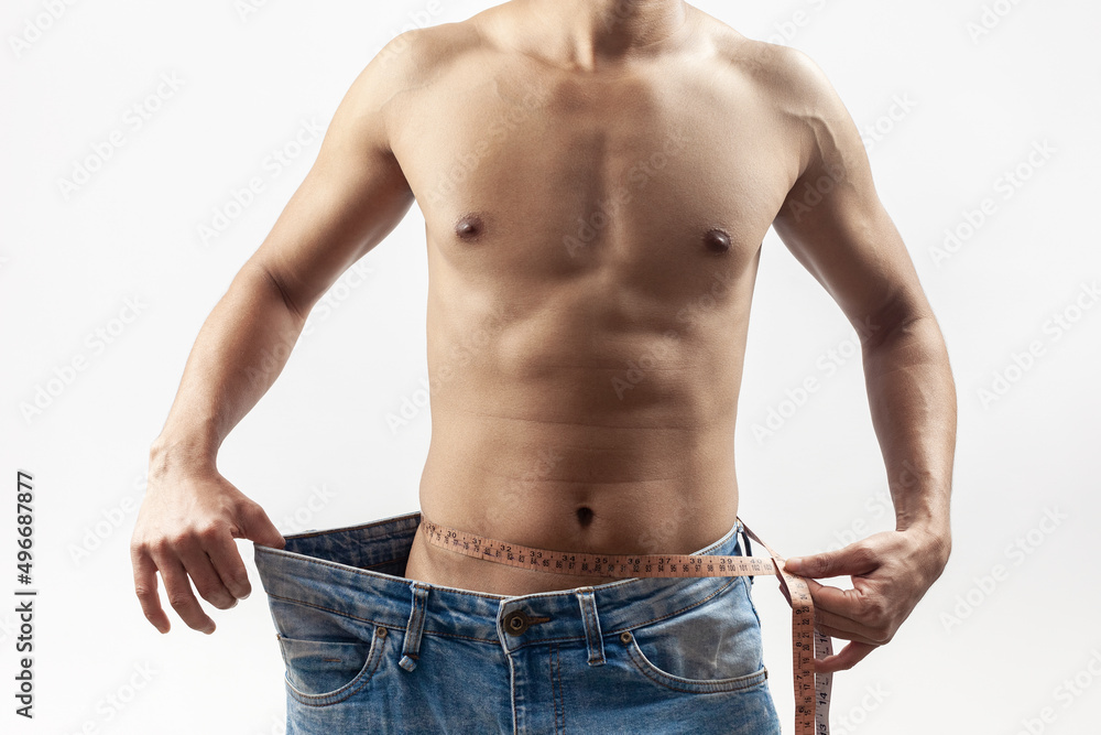 Foto de Fitness model, strong diet, fat burn. An asian man measuring ...