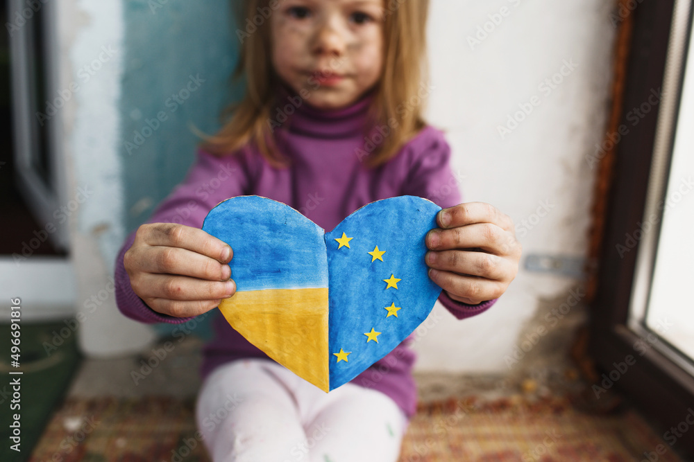 a little Ukrainian girl with a face blackened by fire is sitting on the ...