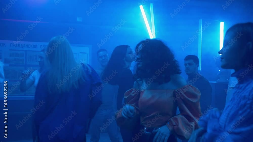 A crowd of people dancing on the dance floor of a nightclub under the ...