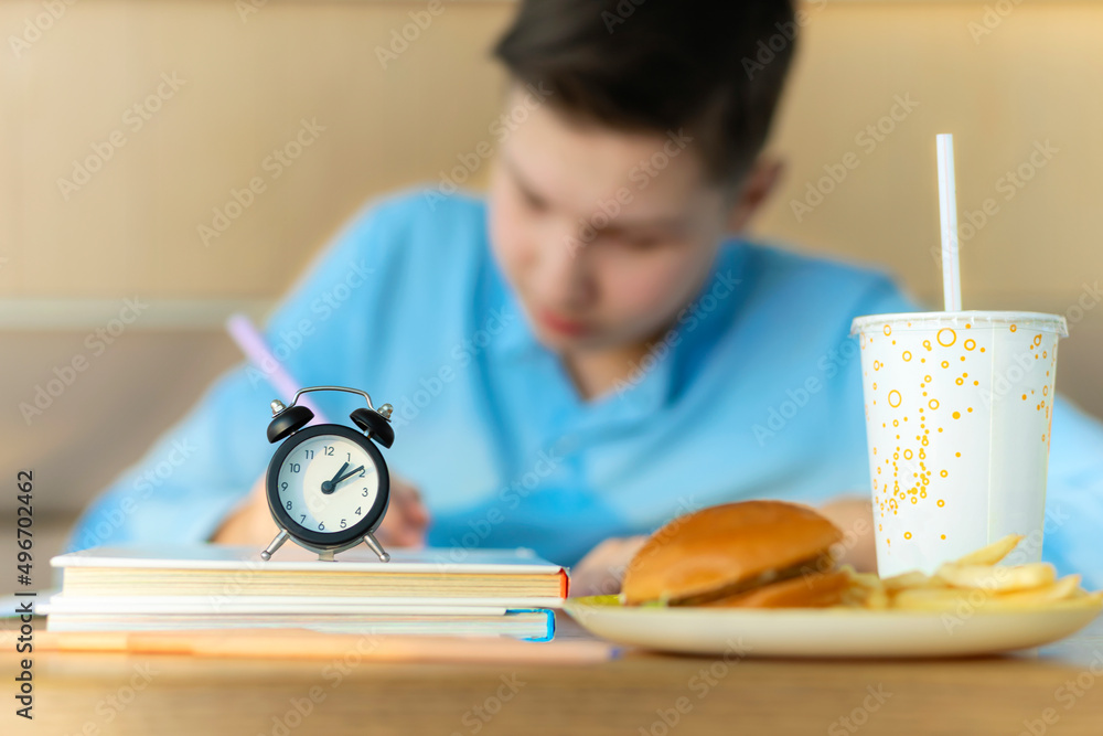 schoolchild doing homework, studing at school. boy waiting for lunch ...