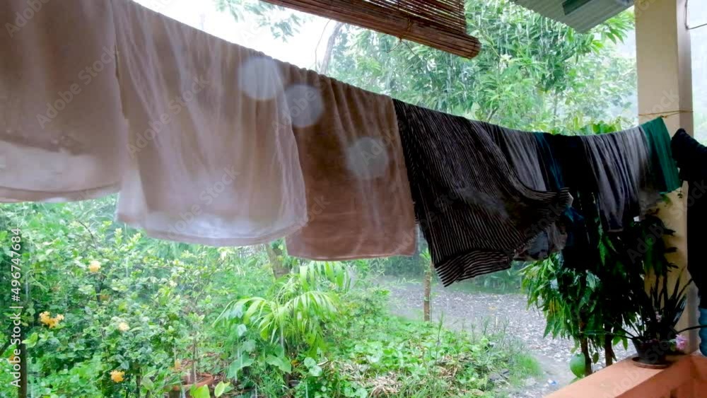 Drenched wet clothes on the washing line during rain and windy weather ...