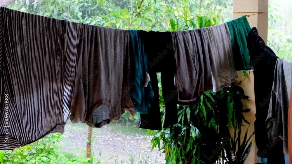 Wet clothing hung out on washing line to dry during a big heavy rain ...