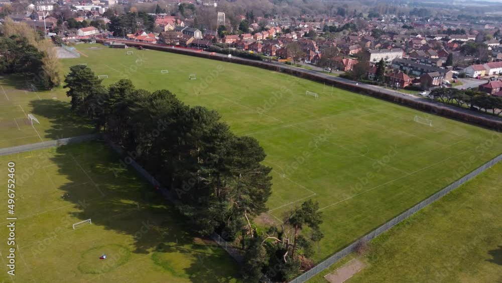 Top rotating aerial view on lush green football field hidden in forest ...