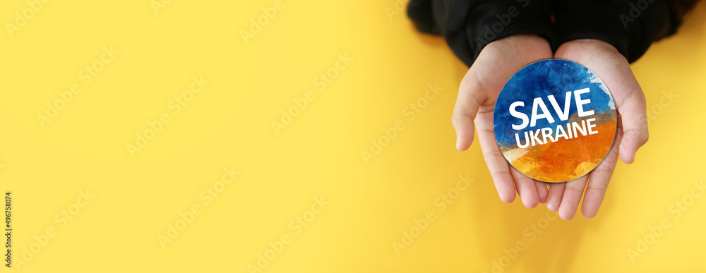 Paper board with Ukraine flag color and SAVE UKRAINE text in child ...