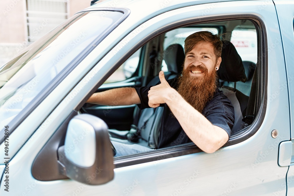 Young irish man smiling happy driving car doing ok sign with thumb up ...