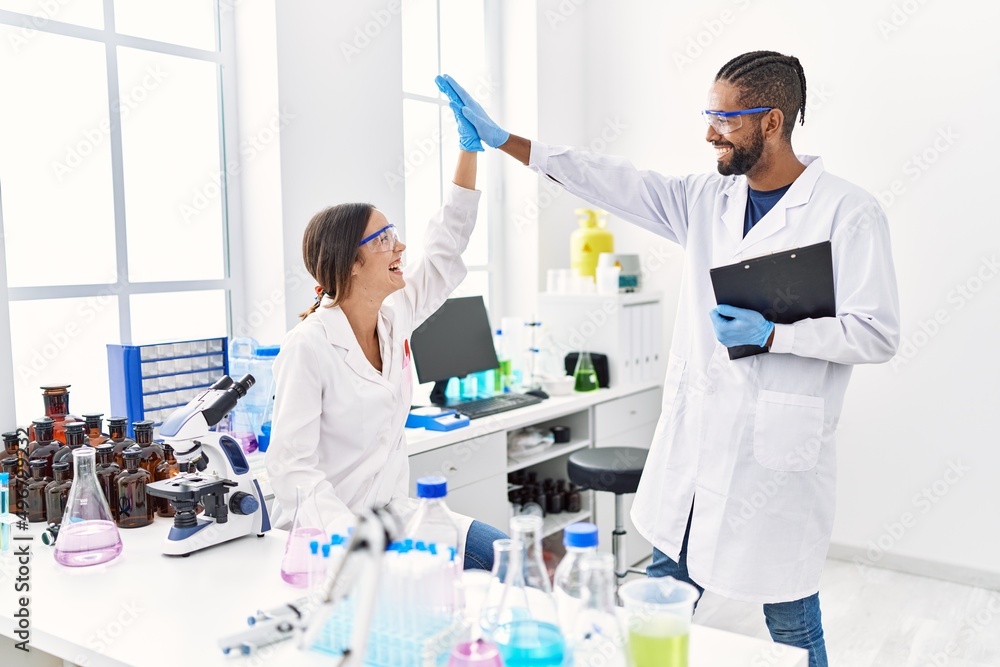 Man and woman scientist partners holding clipboard high five raised up ...