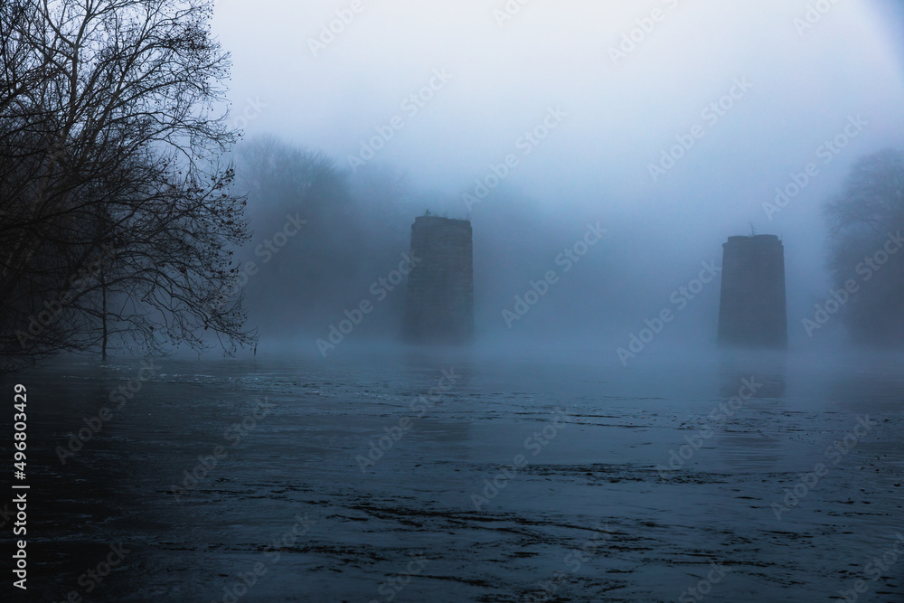 Heavy fog over the lake with a bridge columns in the water Stock Photo ...