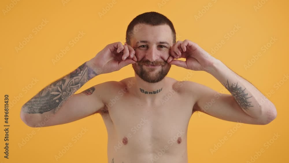 Shirtless European tattooed guy in his 30s touching and playing with ...