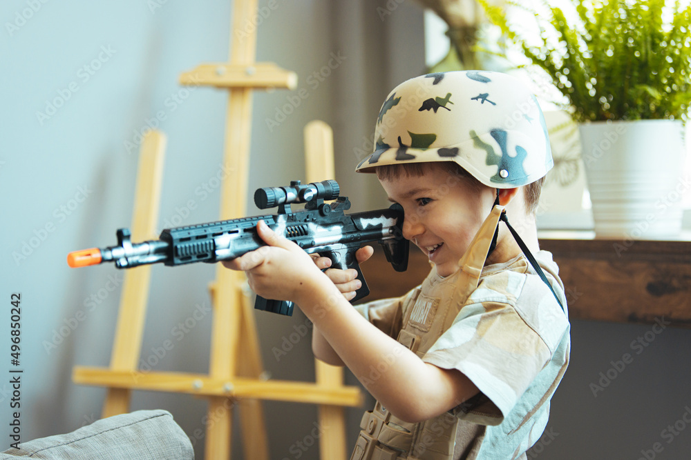 Little boy playing soldiers in living room. In his imagination the boy ...