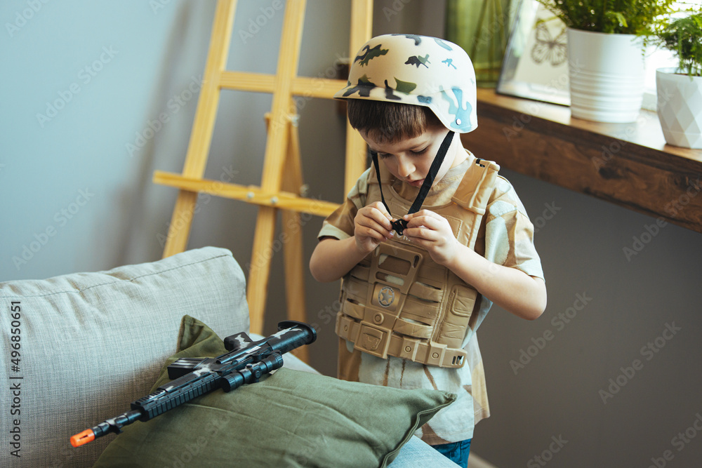 Little boy playing soldiers in living room. In his imagination the boy ...