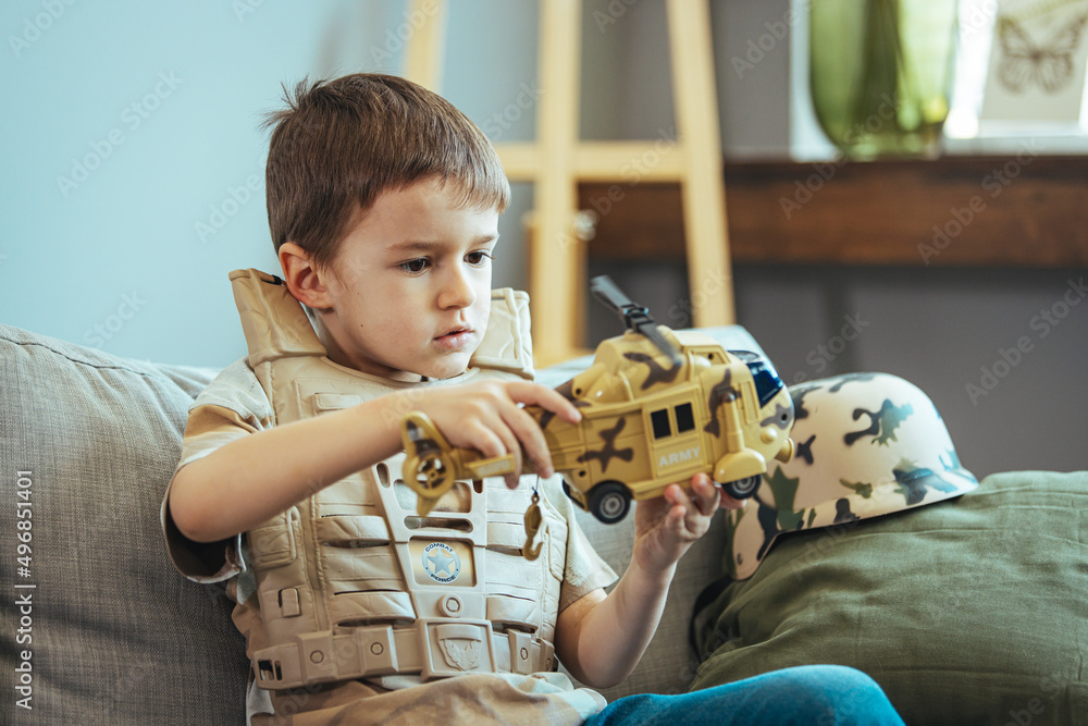 Foto de Little boy playing soldiers in living room. Child is playing ...