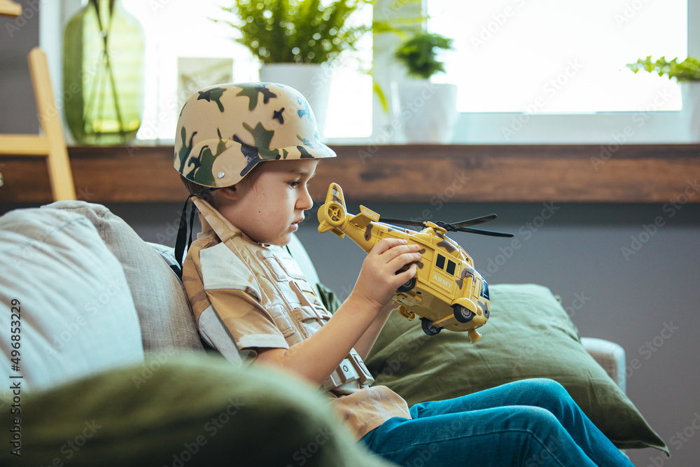 Little boy playing soldiers in living room. Little child is playing ...