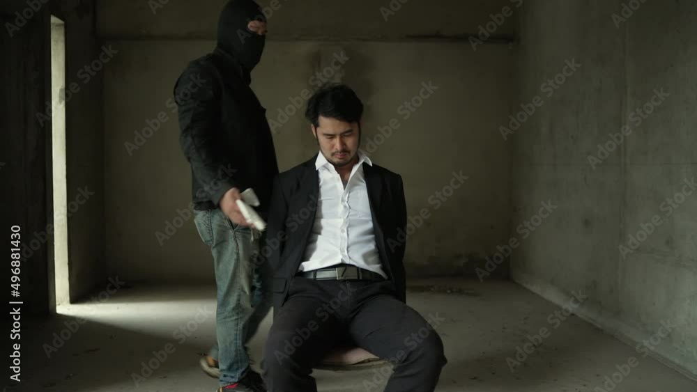 Hostage male He was sitting on a chair, tied with a rope at his feet ...