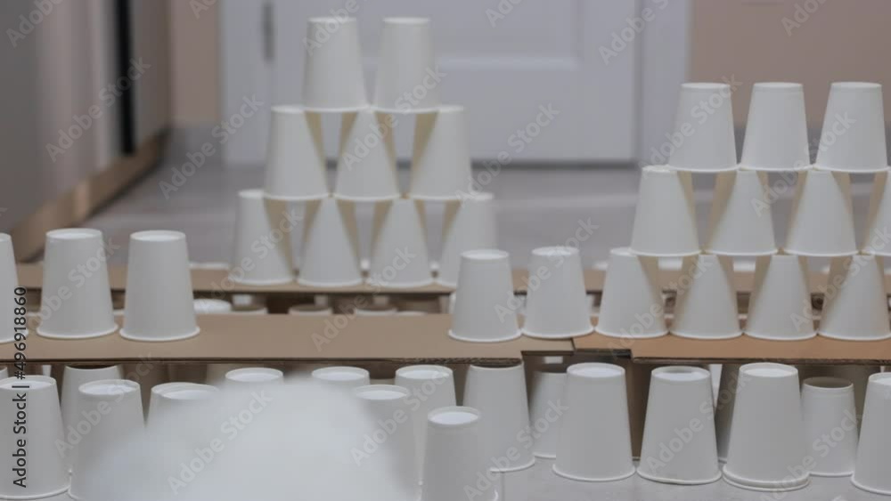 Close-up footage of trained white cat jumping over tower pyramid of ...