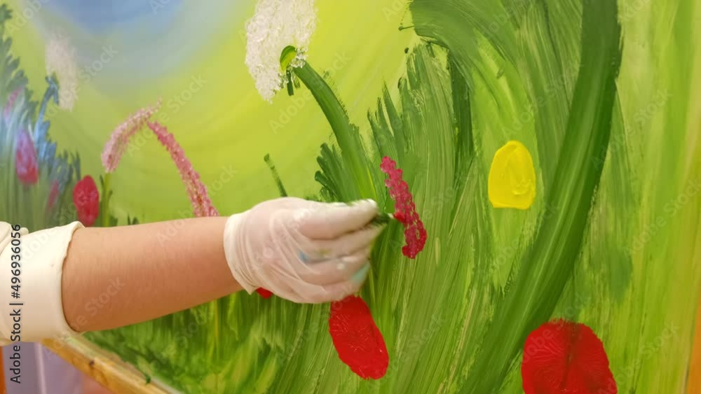 Close-up of a girl drawing with paint on glass. Non-traditional ...