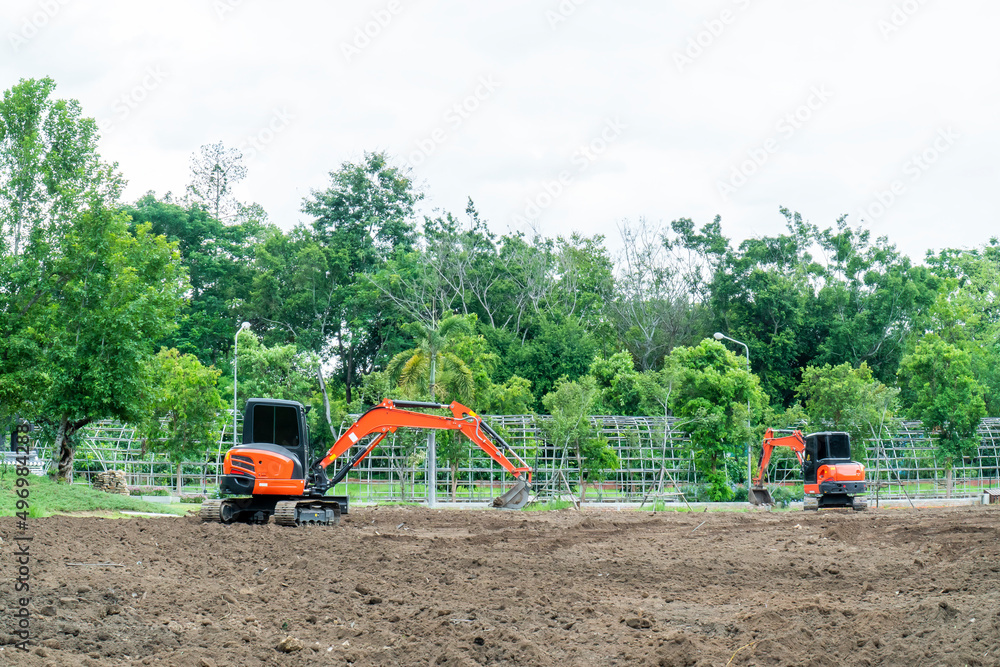 Excavator level the ground in the garden background. Backhoe car ...