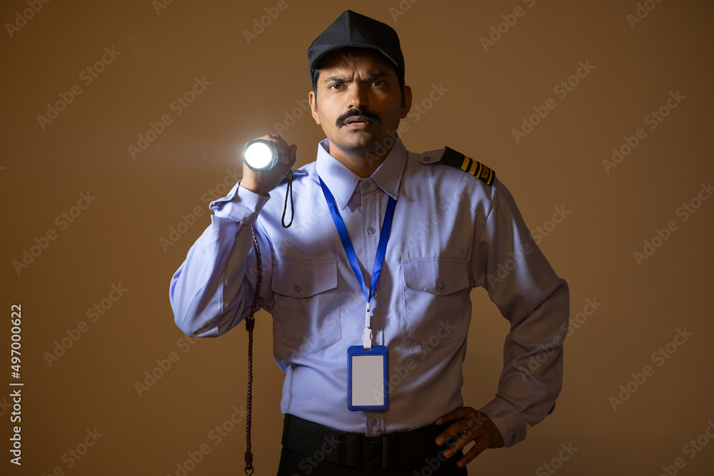 Security guard searching with torch light while working at night Stock ...
