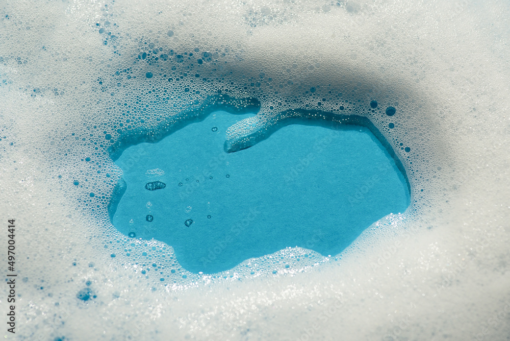 Foam on a blue background. Soapy liquid texture with bubbles. Natural ...