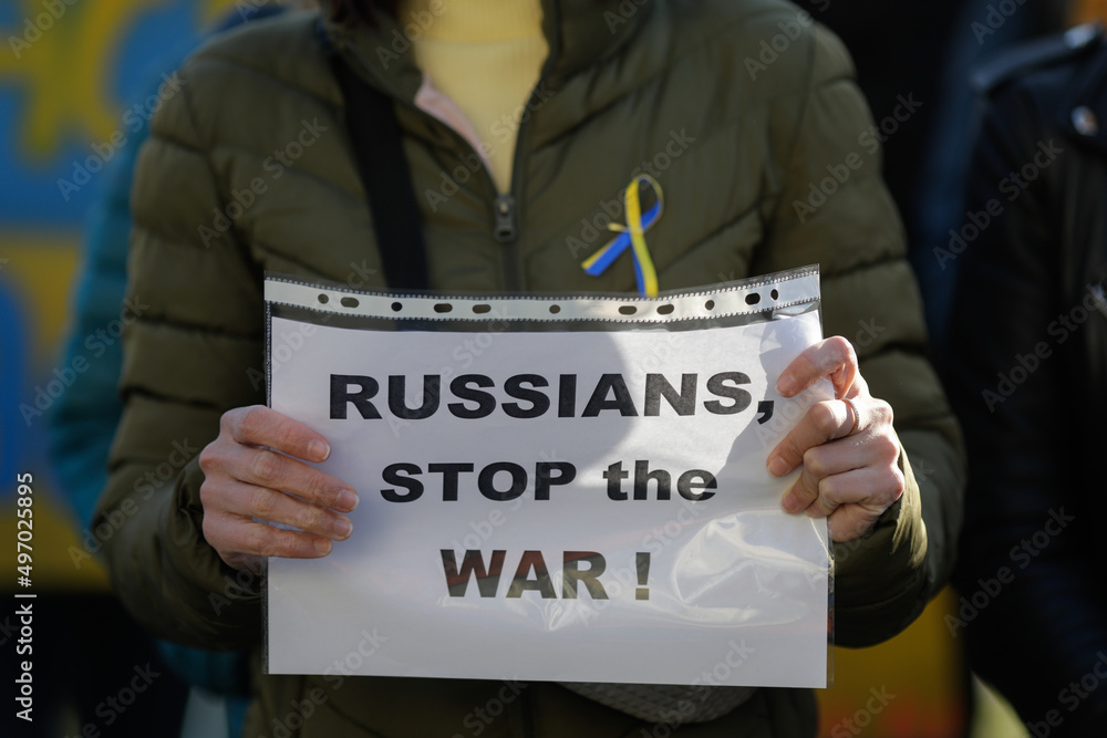 Details with the hands of an Ukrainian woman holding an anti war, pro ...