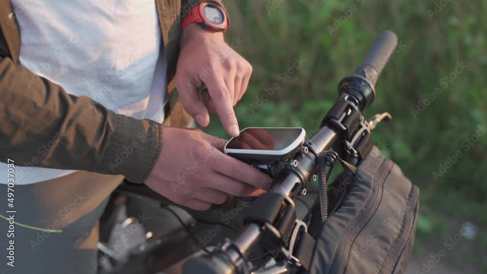 Cyclist use bicycle computer on handlebars of mountain bike in nature ...