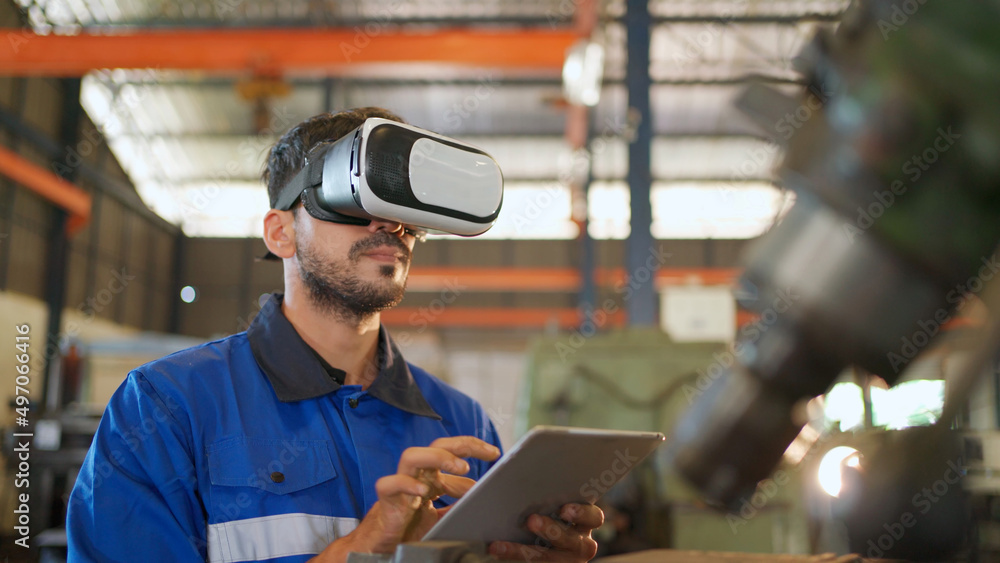 Engineer wearing virtual reality headset standing in the manufacturing ...