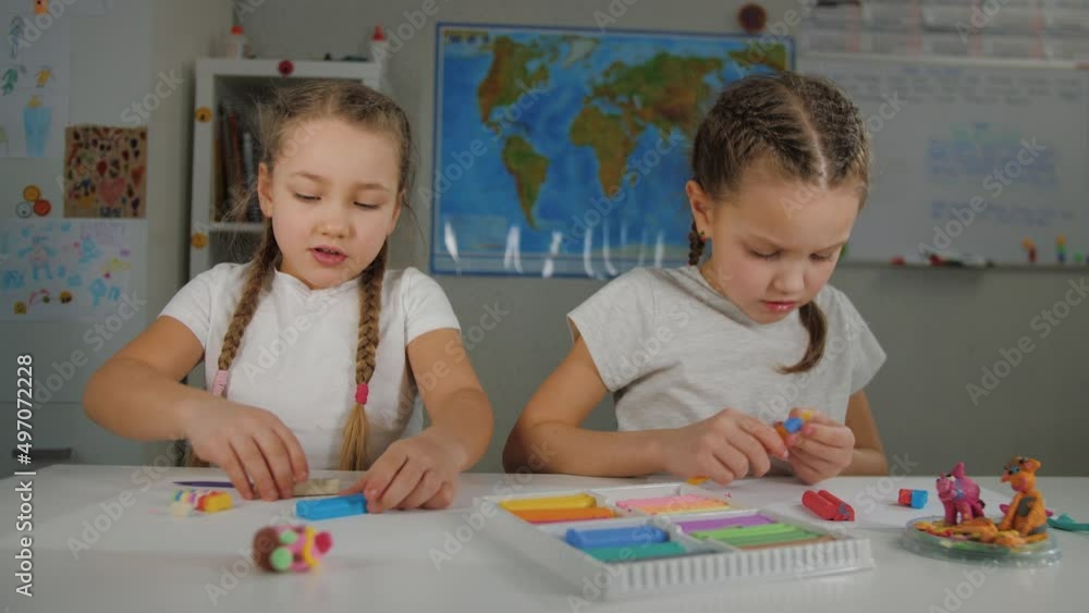 Vidéo Stock Two cute preschool girls making toys sculpting playdough on ...