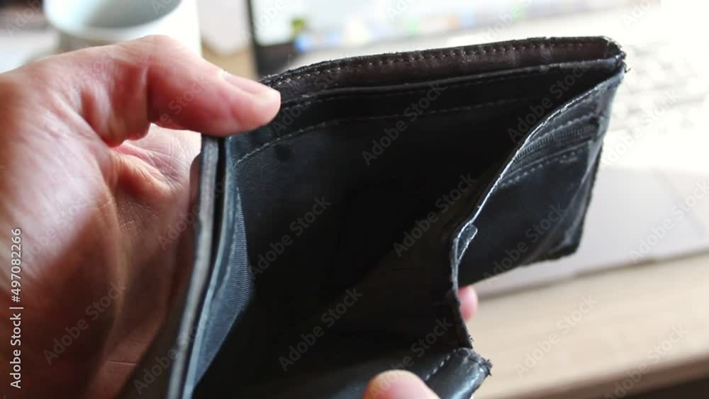 Hands opening a brown leather wallet with no money inside. Static close ...