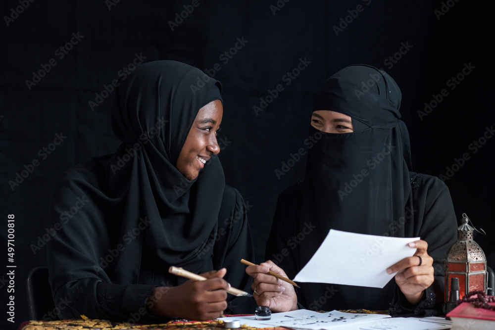 Muslim women wearing black hijab learn to writing Arabic calligraphy ...