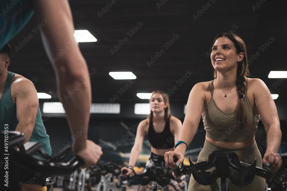 people on bikes in spinning class in modern gym, exercising on ...