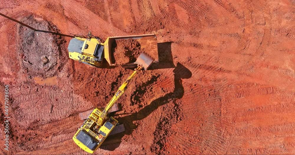 Aerial top view of excavator working at backhoe digs ground for laying ...