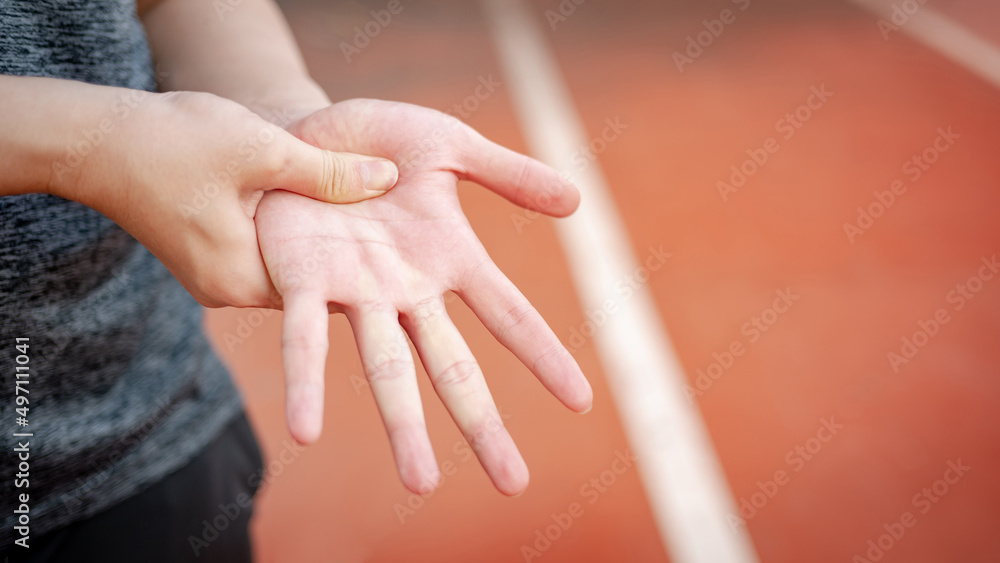 Athlete male hand holding his painful wrist for healing the pain while ...
