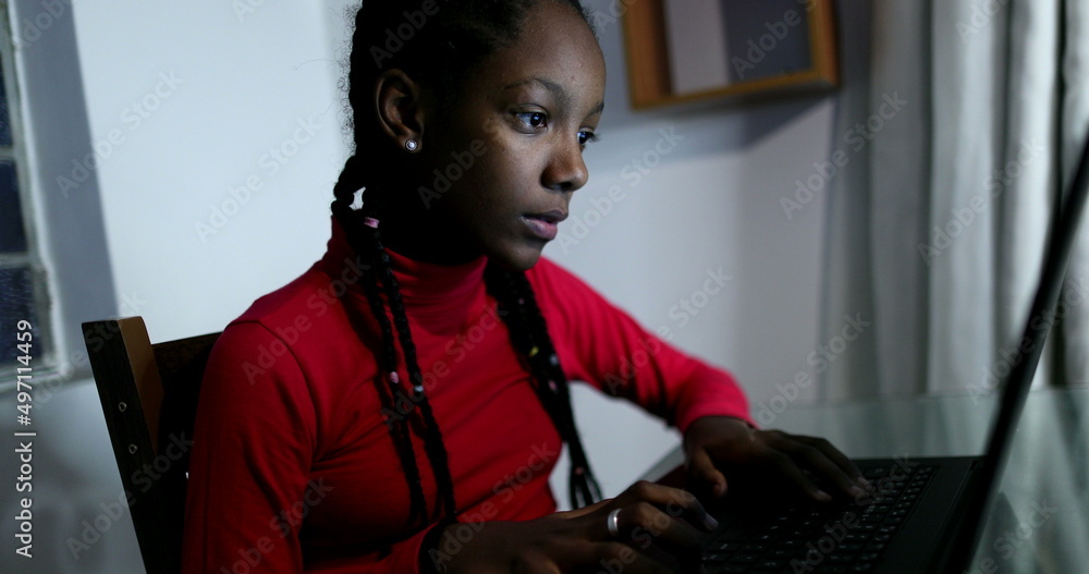 Teenager looking at computer screen at night browsing internet, black ...