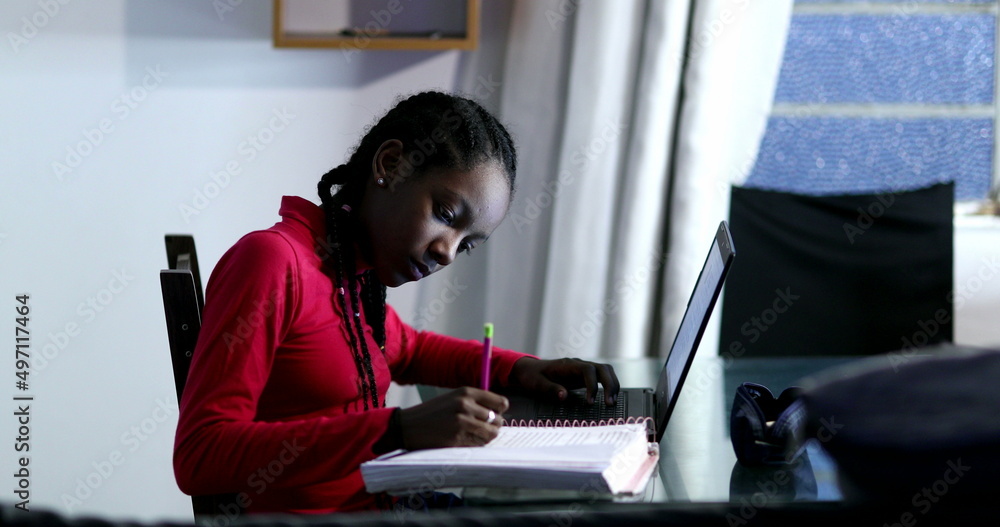 Teen African girl doing homework at night, black adolescent female ...