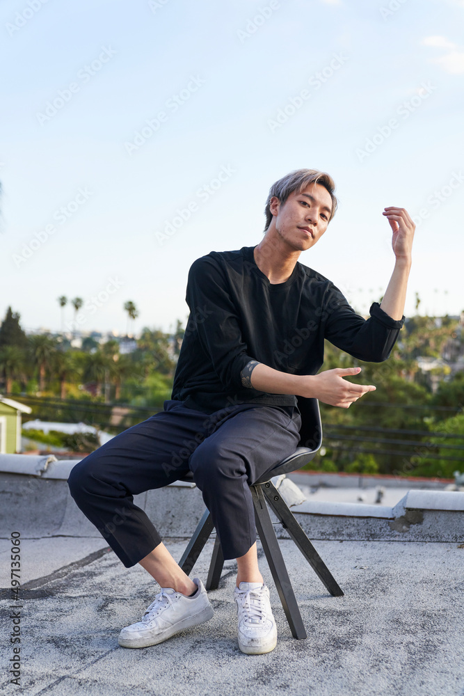 Man dancing outdoors sky and palm trees sitting on chair Stock Photo ...